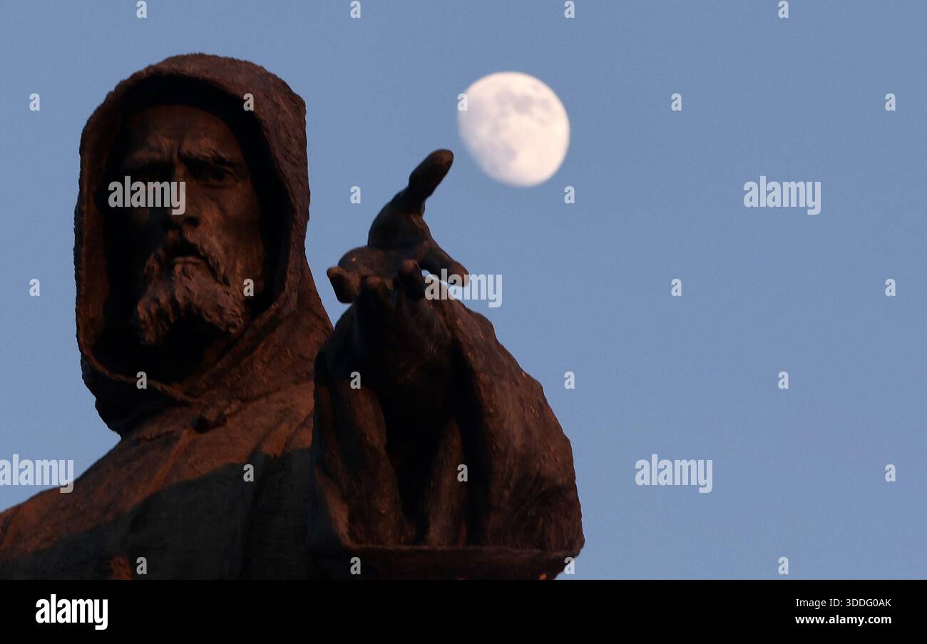Brescia , Italy. 31th December 2025. The Moon is seen above the Statue ...