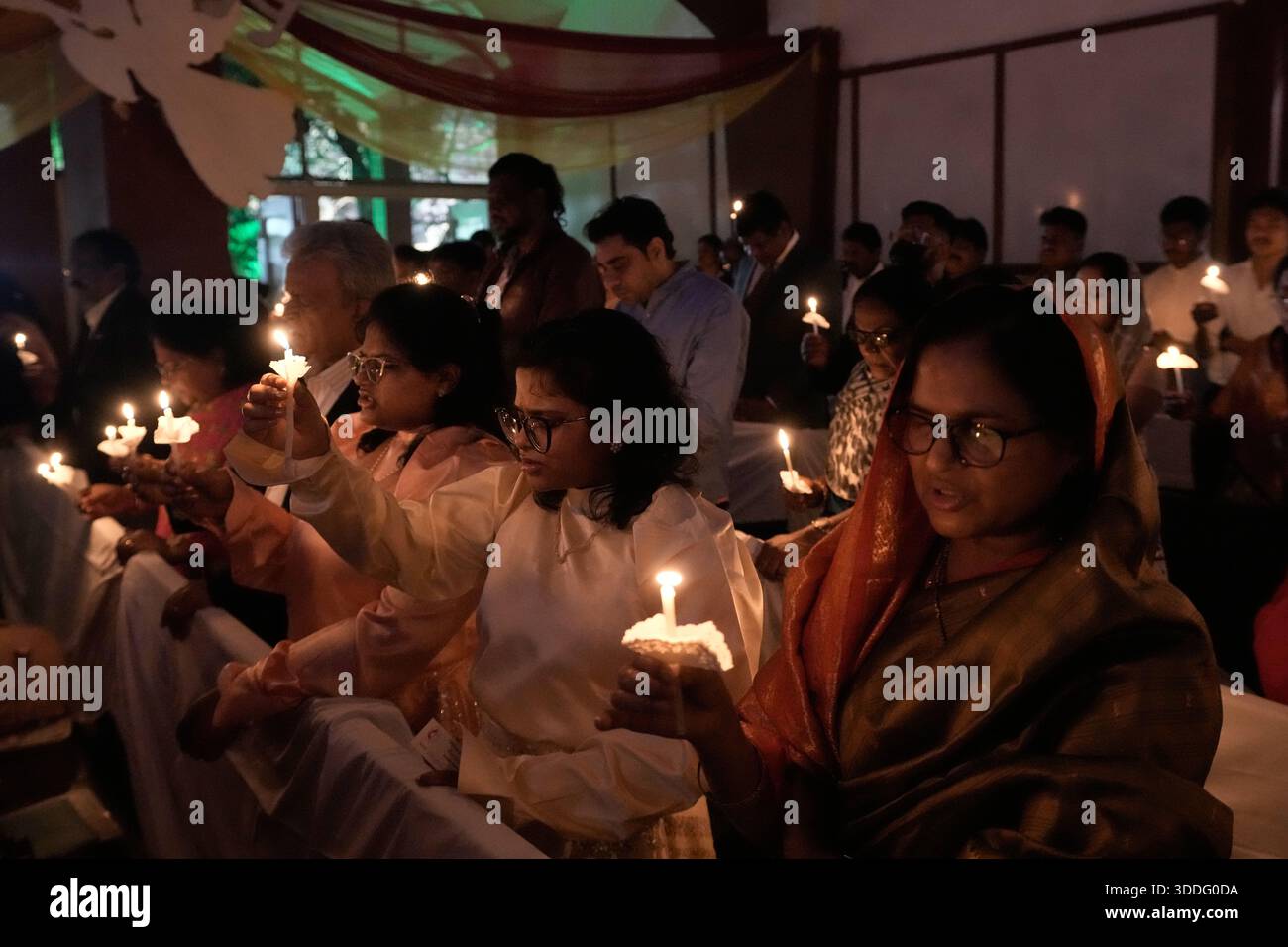 Indian Christians hold candles and offer prayers during a New Year ...