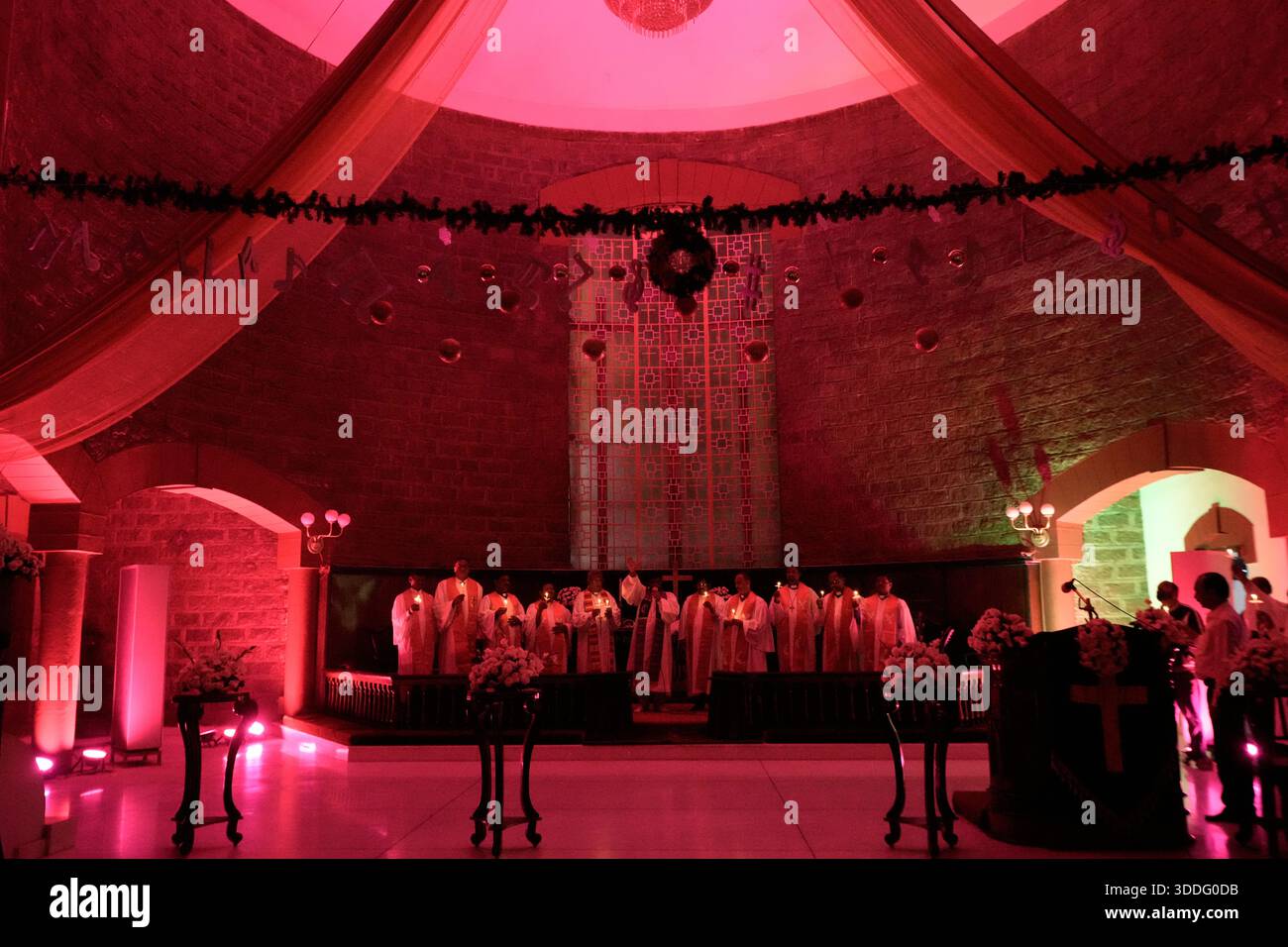 Indian pastors hold candles and offer prayers during a New Year worship ...