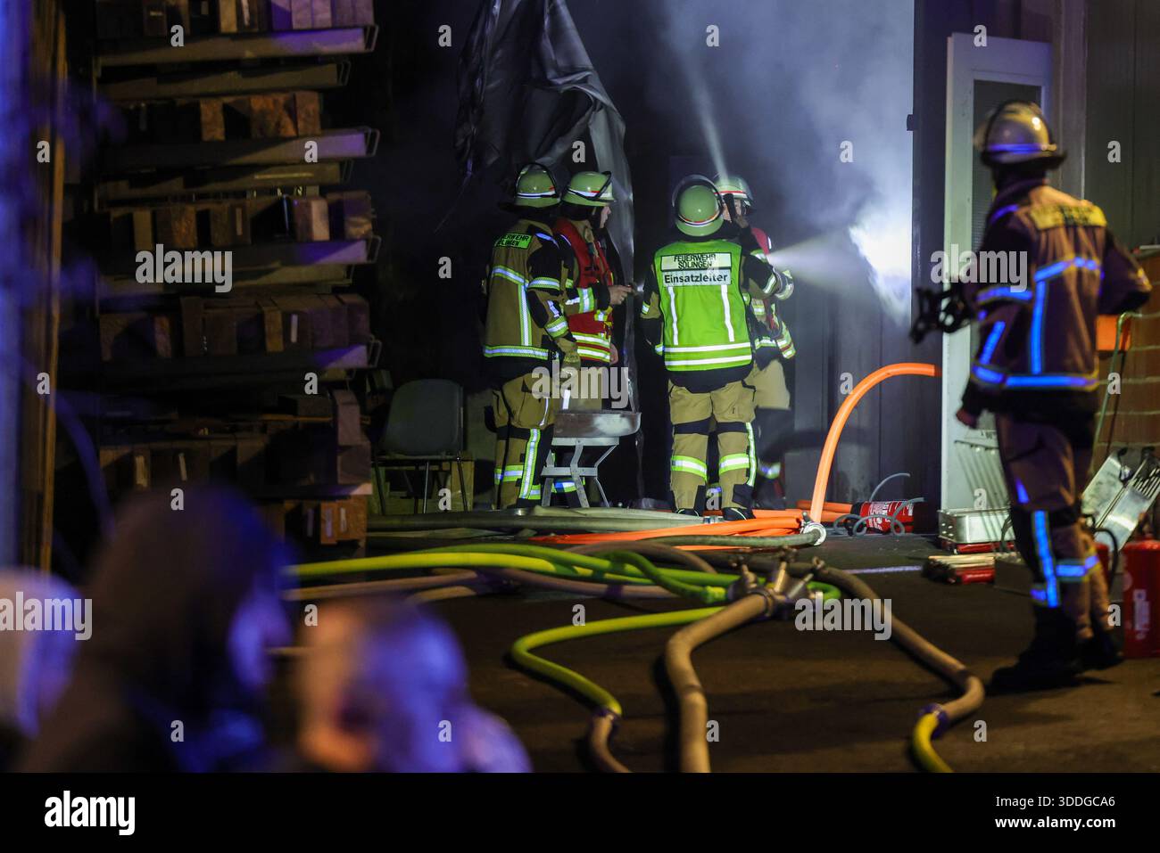 01 January 2026, North Rhine-Westphalia, Solingen: Firefighters stand ...