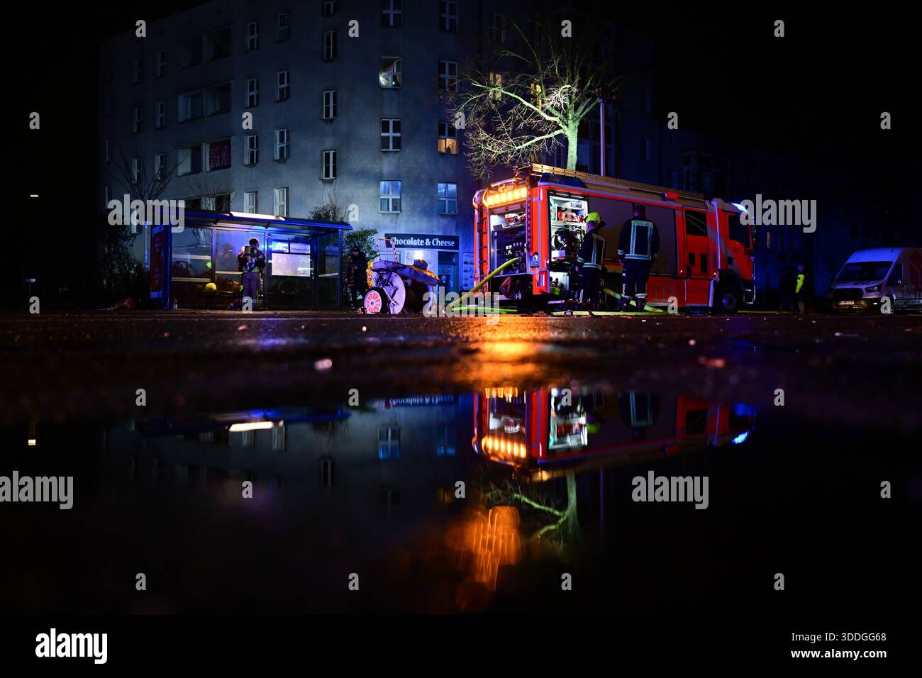 01 January 2026, Berlin: Fire department vehicles stand in front of a ...