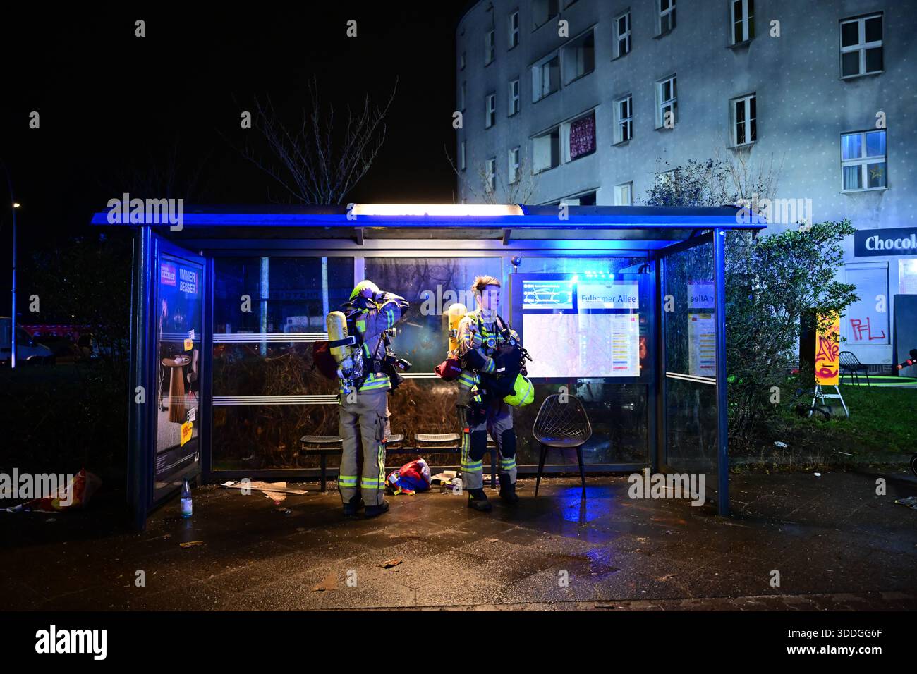01 January 2026, Berlin: Firefighters stand at a bus stop after ...