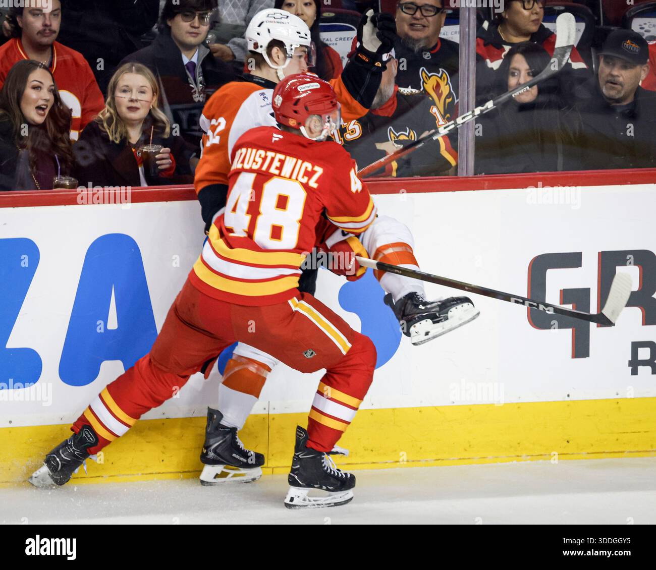 Philadelphia Flyers' Denver Barkey, left, is checked by Calgary Flames ...