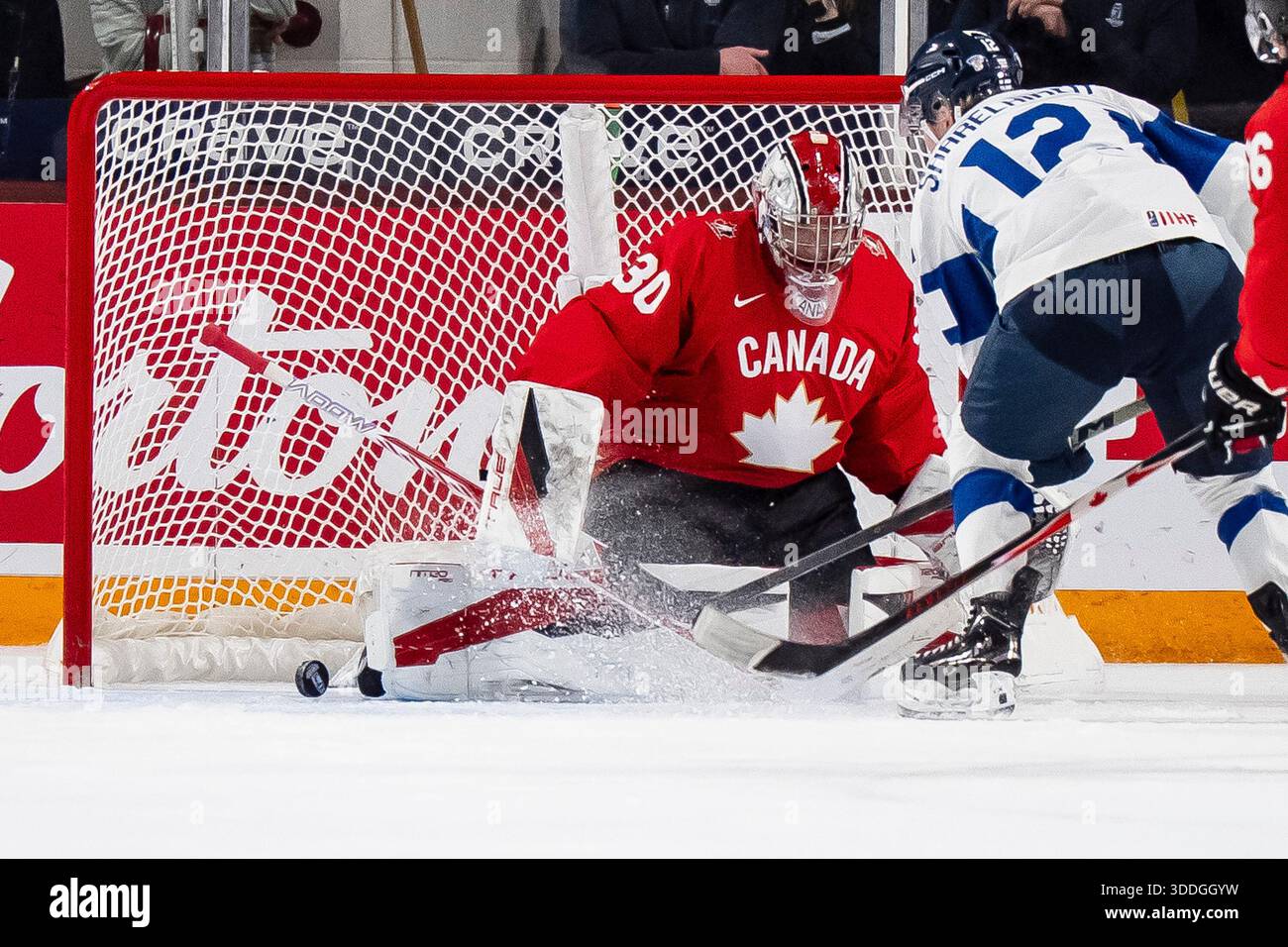 Canada goaltender Carter George (30) makes a save on Finland's Joona ...