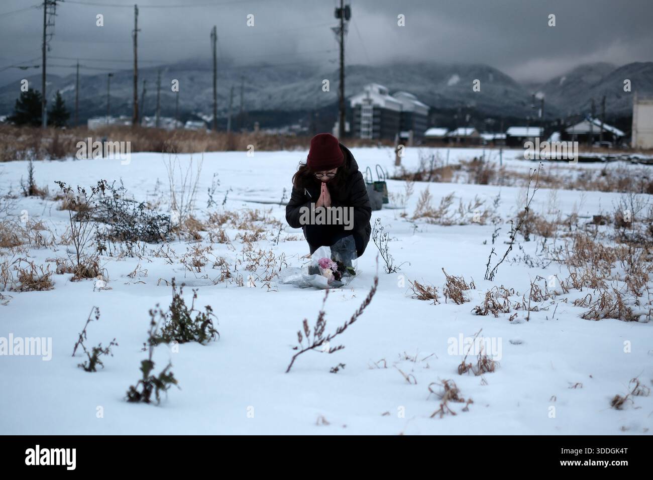 65-year-old Kumiko Hatanaka offers a bunch of flowers and prays ...