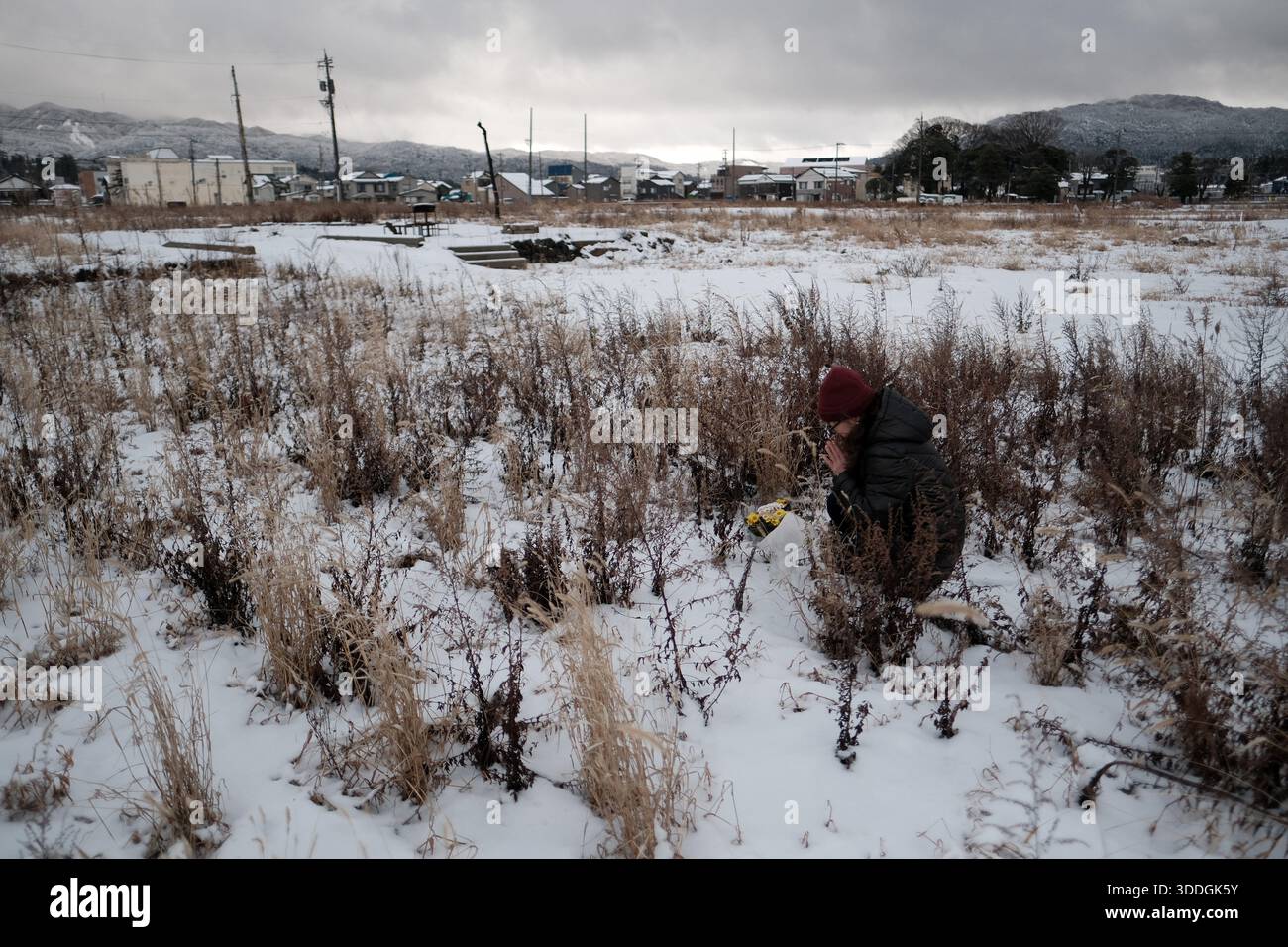 65-year-old Kumiko Hatanaka offers a bunch of flowers and prays ...