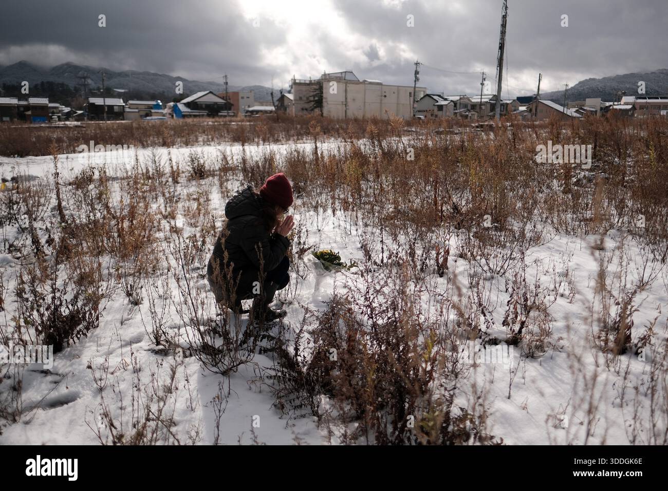 65-year-old Kumiko Hatanaka offers a bunch of flowers and prays ...