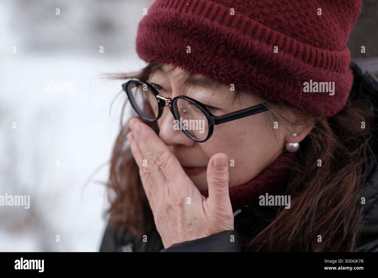 65-year-old Kumiko Hatanaka offers a bunch of flowers and prays ...
