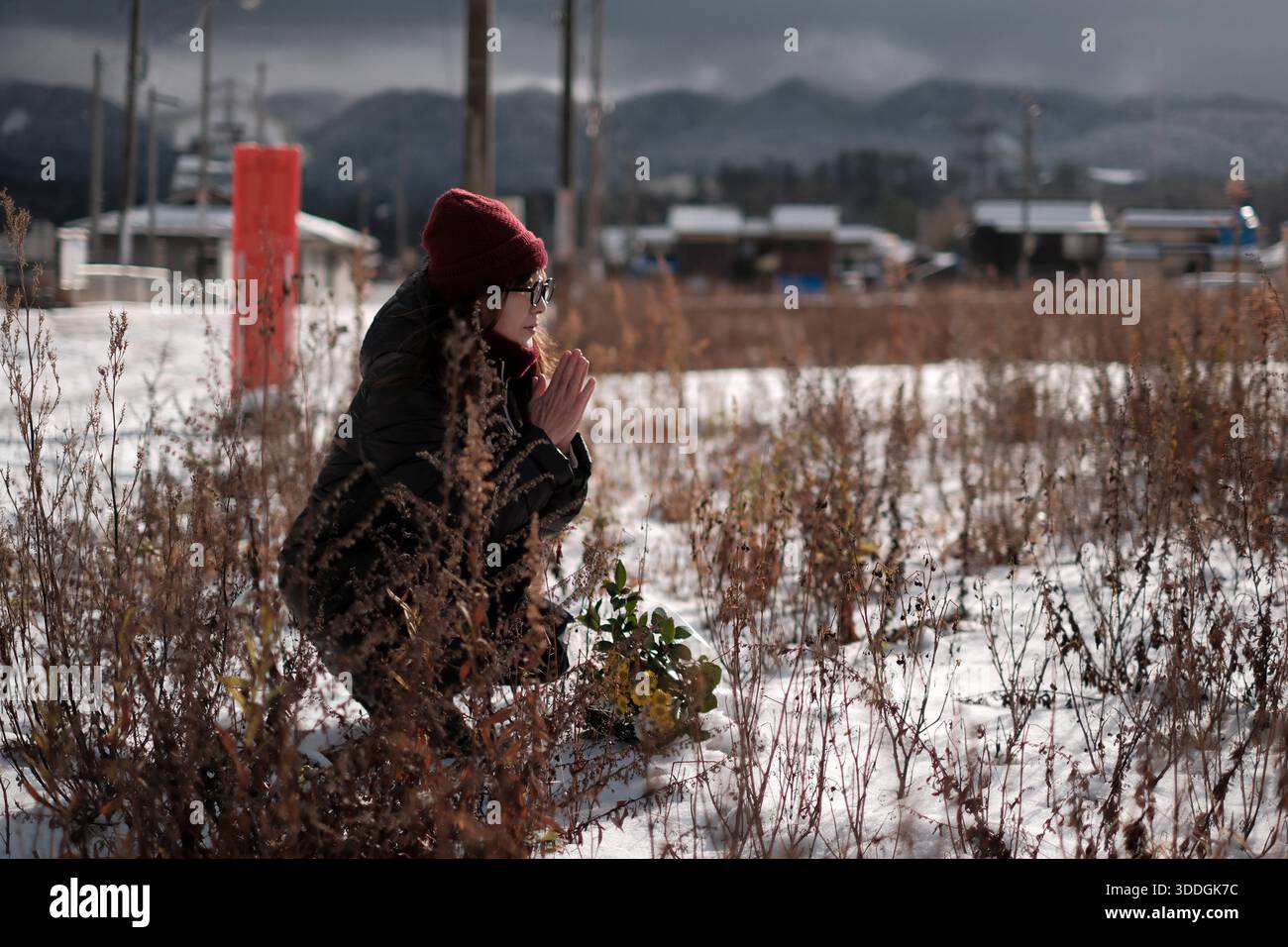 65-year-old Kumiko Hatanaka offers a bunch of flowers and prays ...