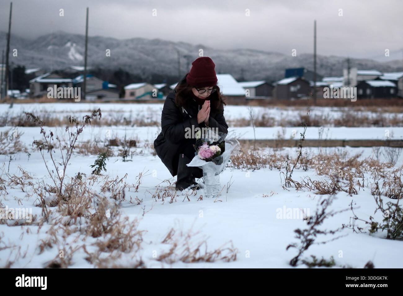 65-year-old Kumiko Hatanaka offers a bunch of flowers and prays ...