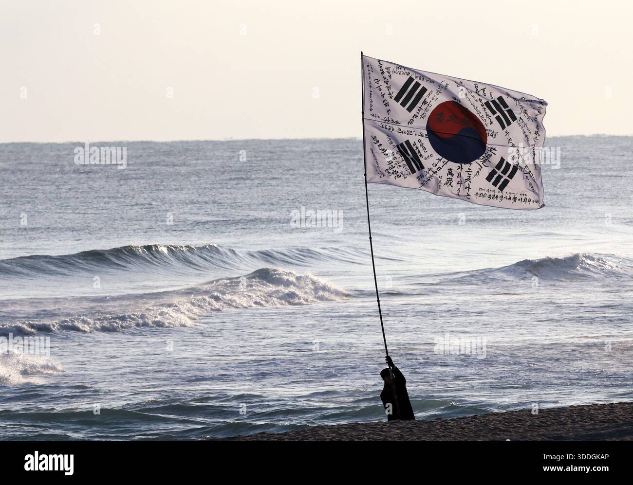 National flag in east sea A man waves the national flag, the Taegeukgi ...