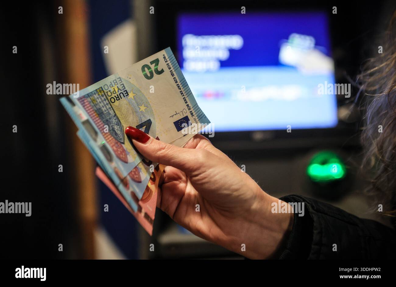 A person poses with euro banknotes withdrawn from an ATM in Sofia ...