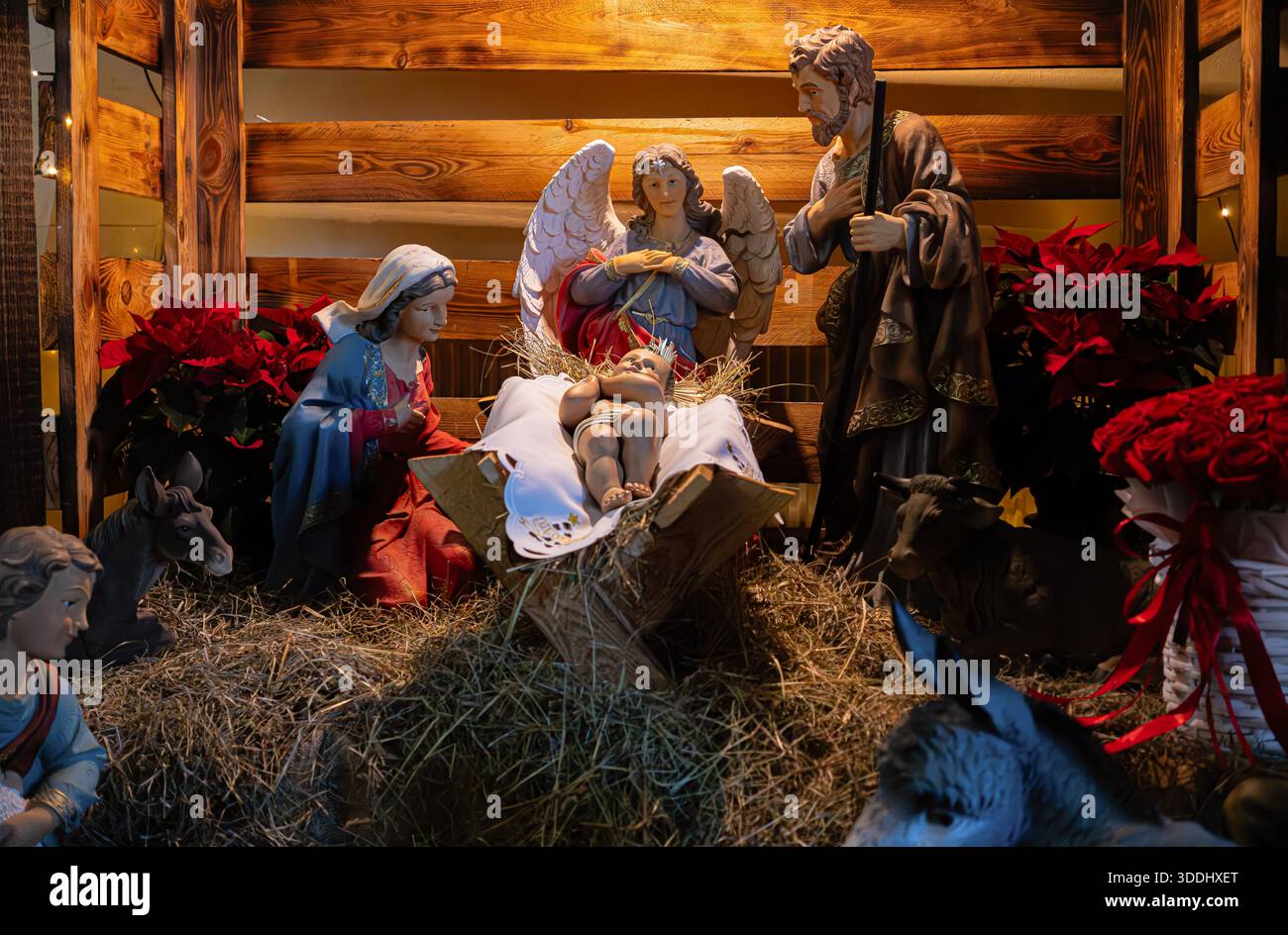This image depicts a traditional Nativity scene (crèche) with statues ...