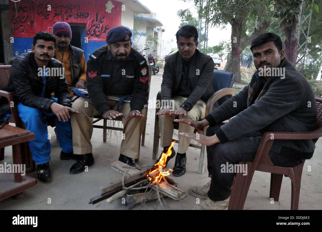 HYDERABAD, PAKISTAN, JAN 01: Police officials are warming their hands ...