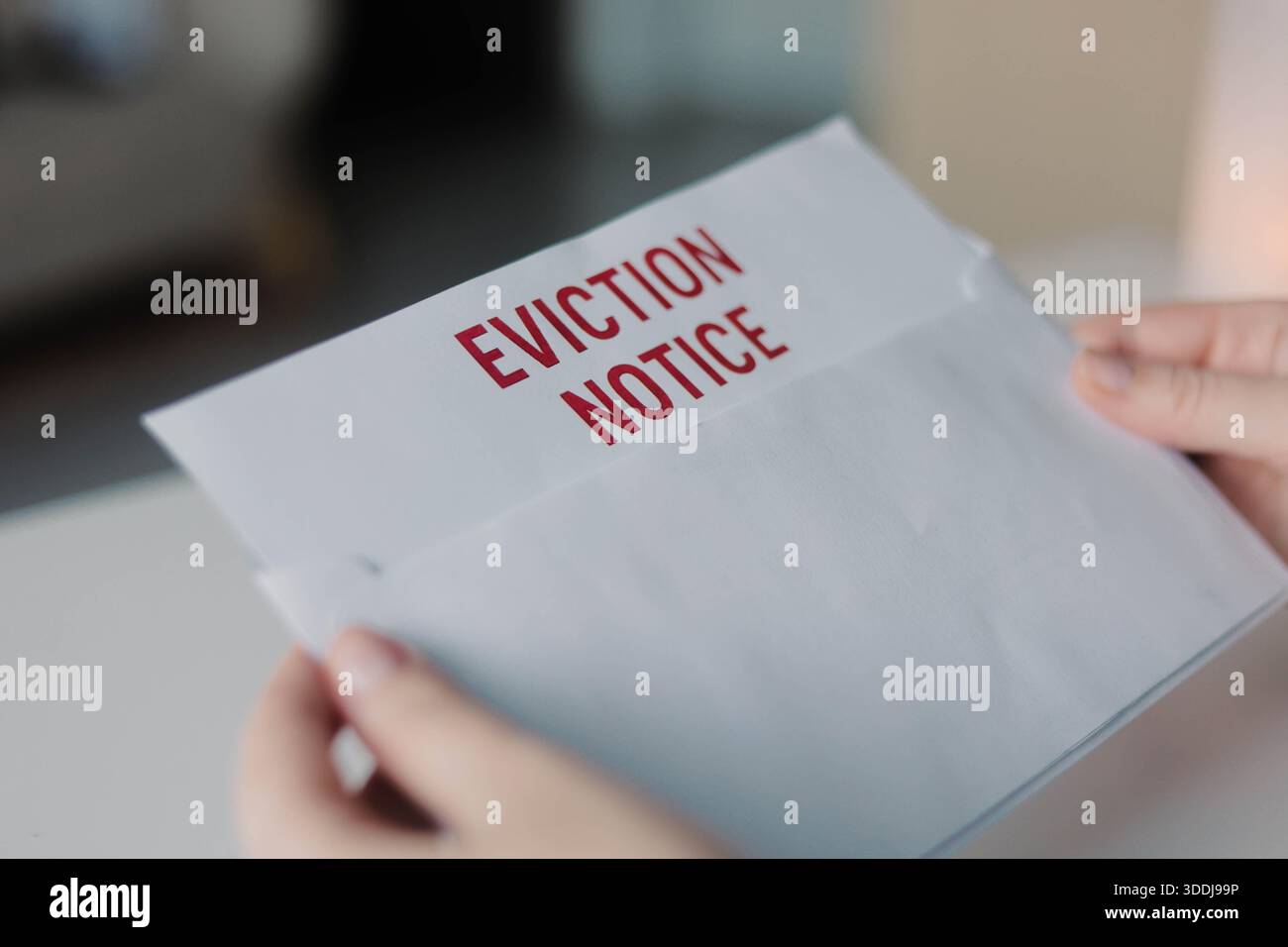 Person pulling an eviction notice letter from a white envelope. Concept ...