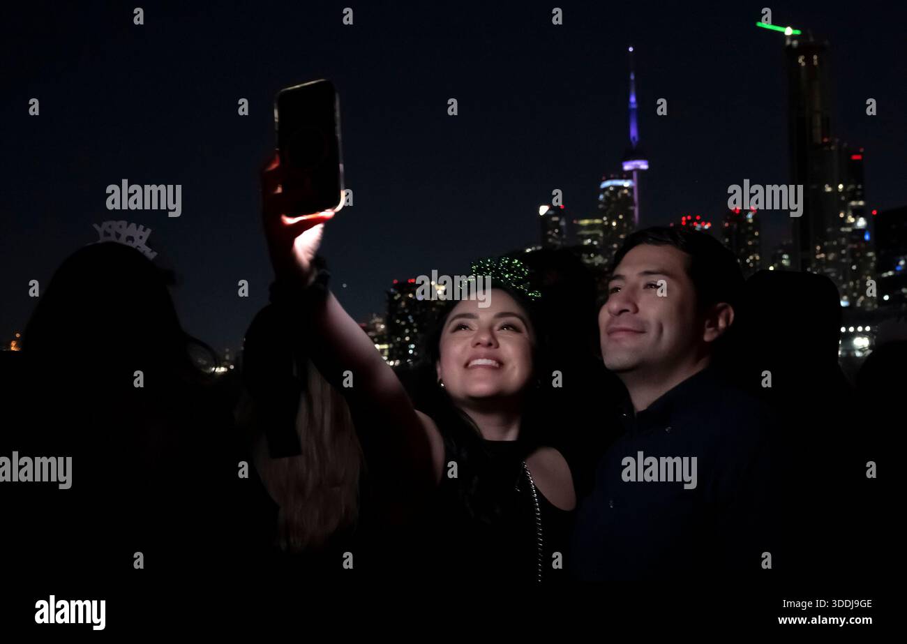 Revellers watch as fireworks light up Toronto's inner harbour to ring ...