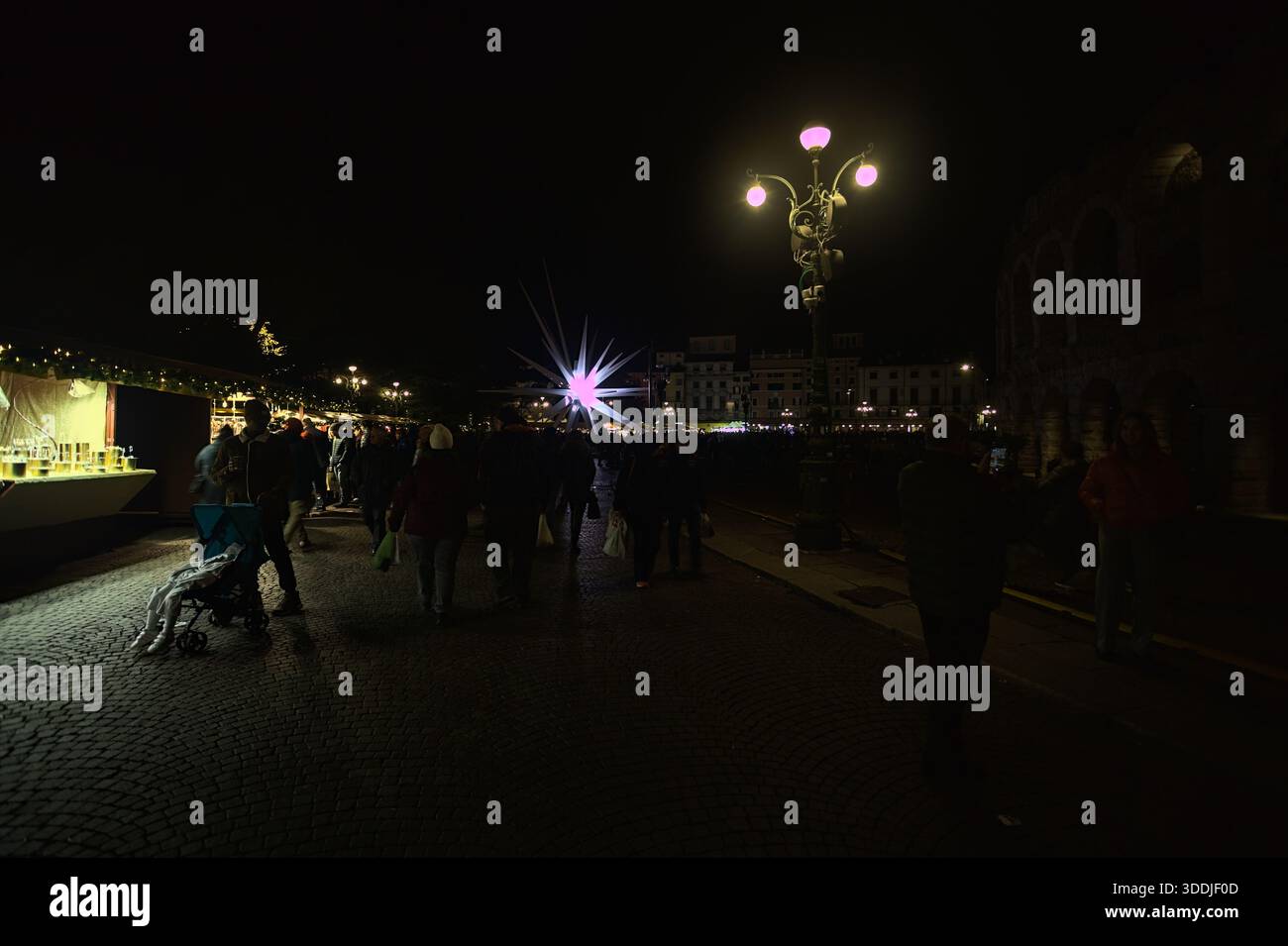 Verona, Italy - 8TH DECEMBER 2025 - Lit Christmas market stalls next to ...