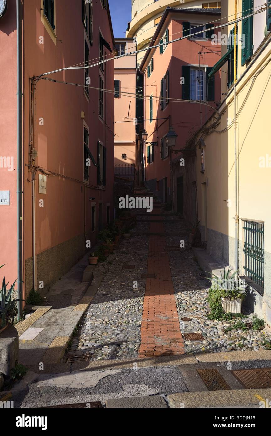 Entrance in the shade to a climbing alley made with stairs on ...