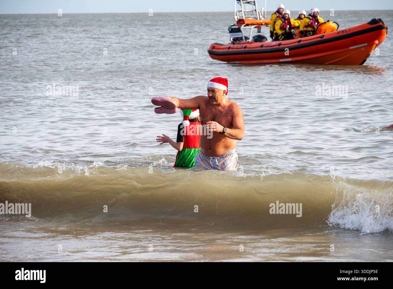 A swimmer tries to save a pair of slippers at the sea during the New ...