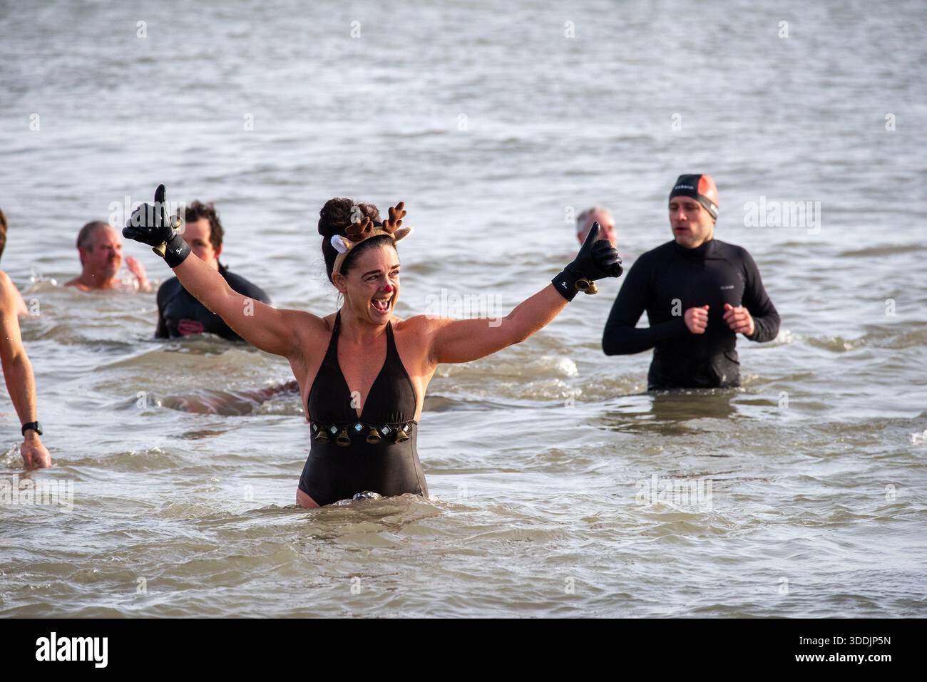 A swimmer enjoys the water and shows alright with her thumbs up in ...
