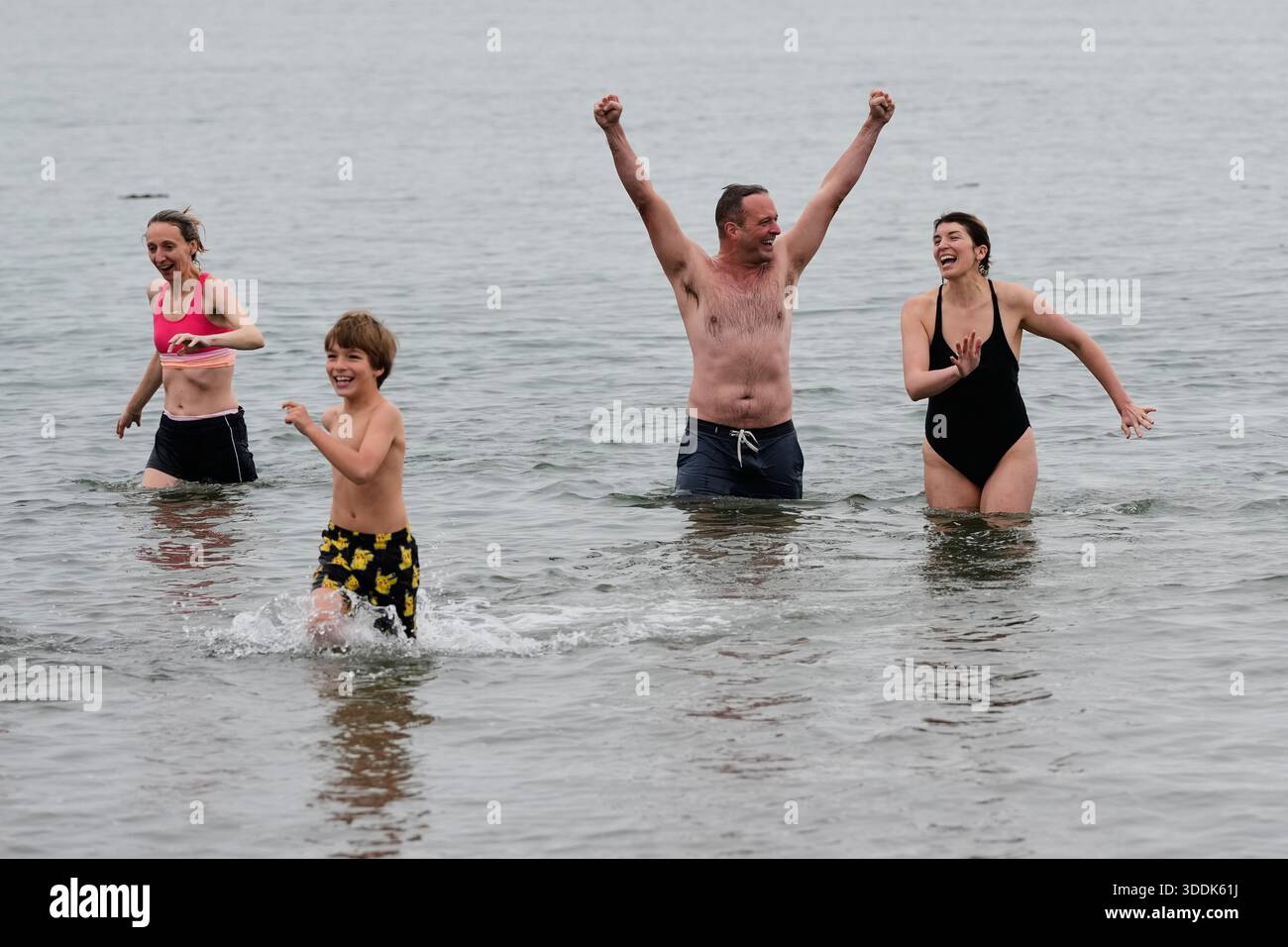 Jeremiah Bonsmith, center, cheers while polar plunging in the San ...