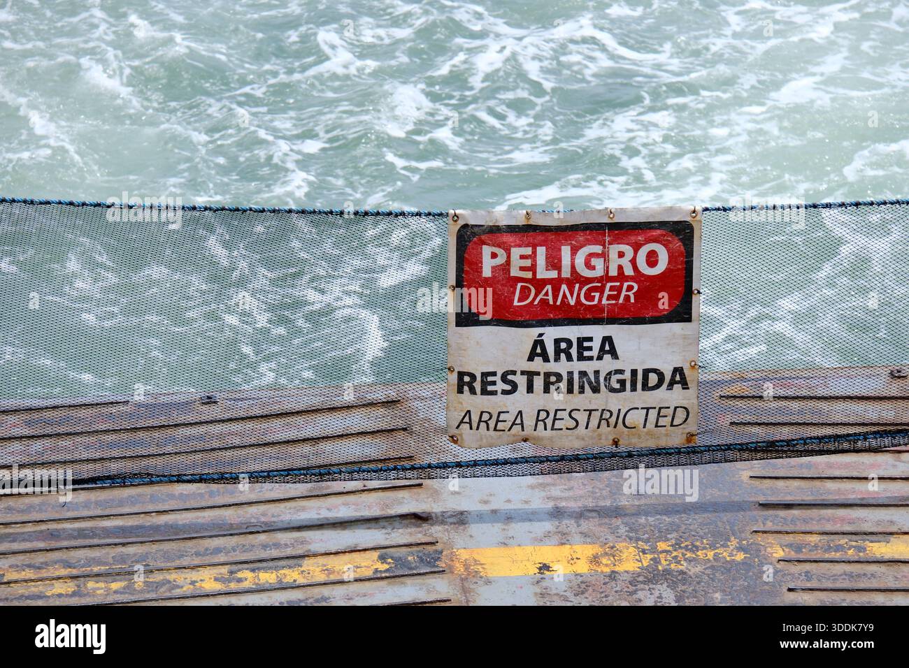 Warning sign reading “Peligro Danger Area Restricted” on a ferry deck ...