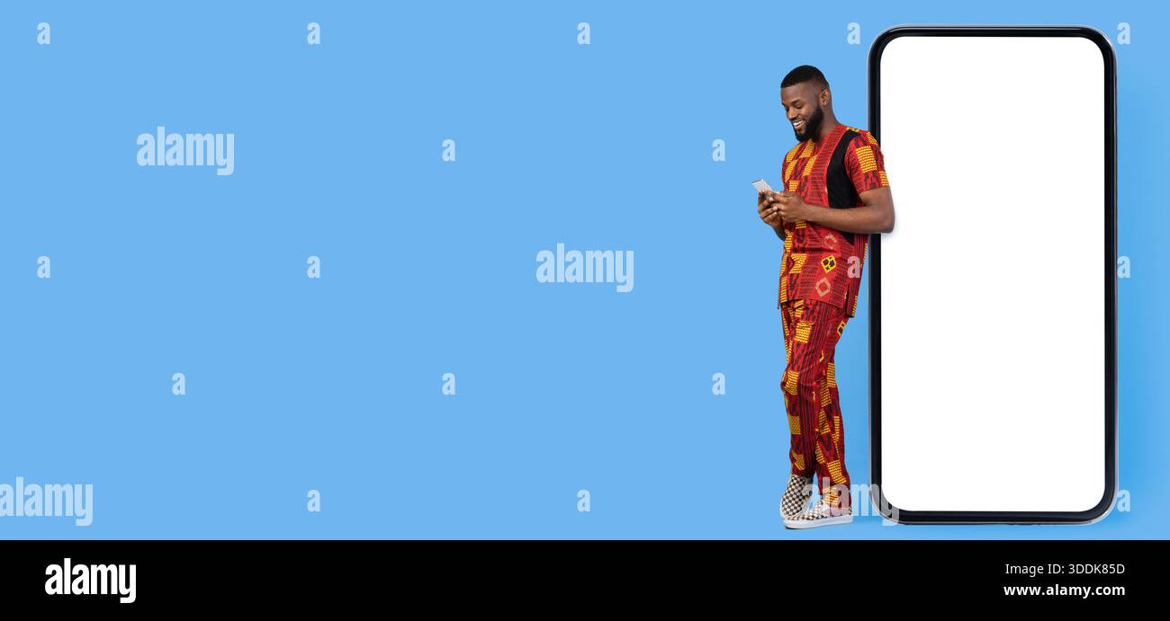Man in Colorful Outfit Using Smartphone Next to Large Blank Screen ...