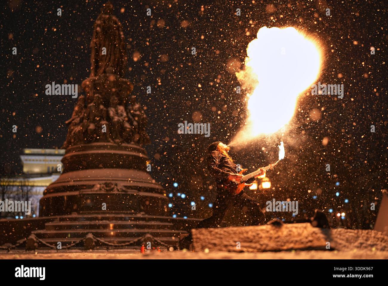FILE - A street performer spits fire and plays a guitar in the snow in ...