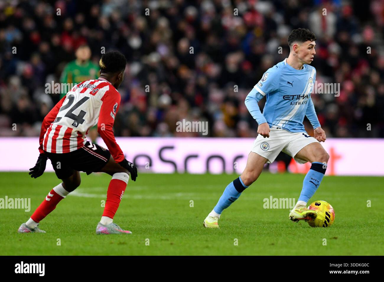 Phil Foden of Manchester City runs with the ball past Simon Adingra of ...