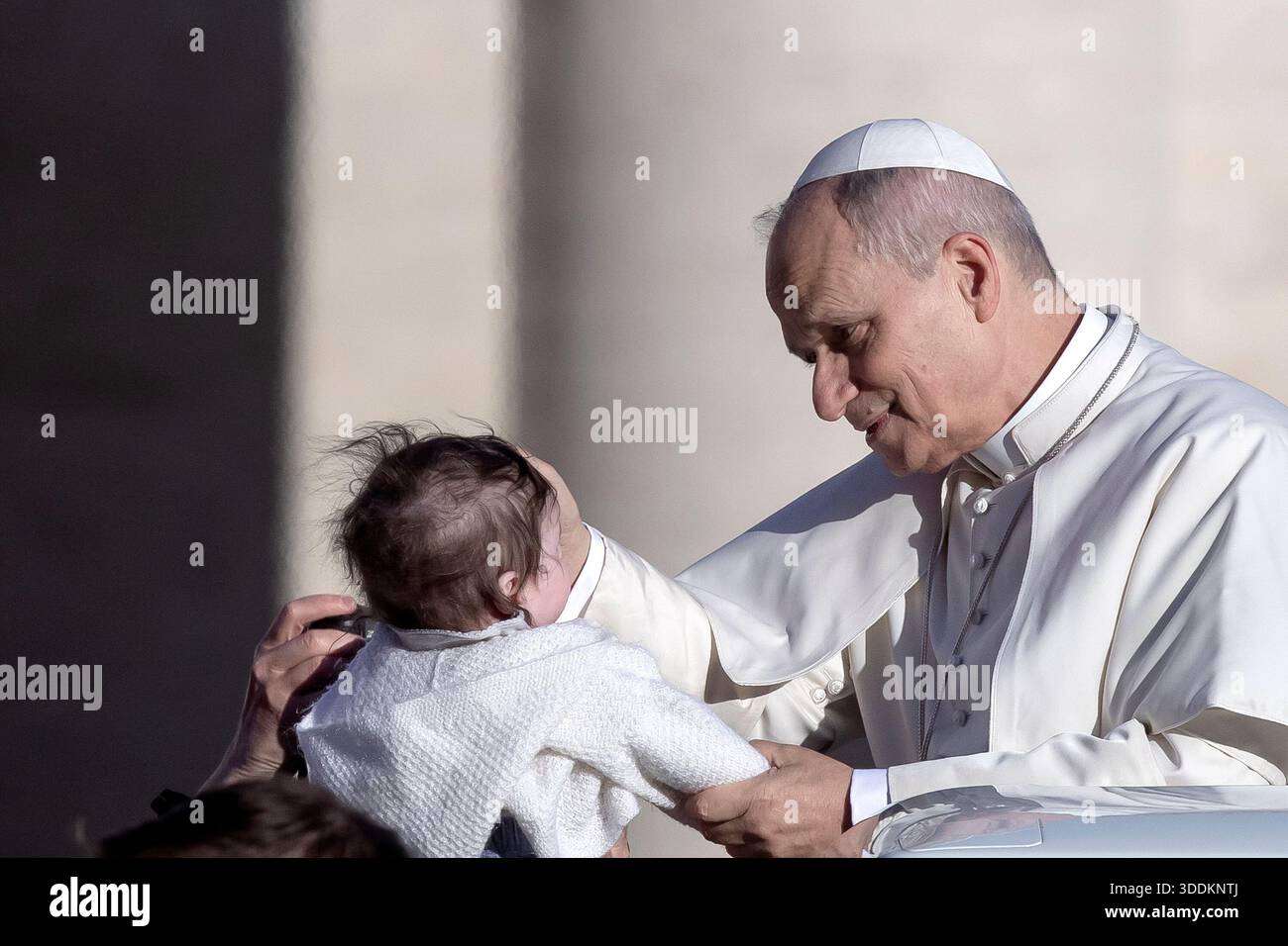 Pope Leo XIV greets a child as he arrives for his weekly general ...