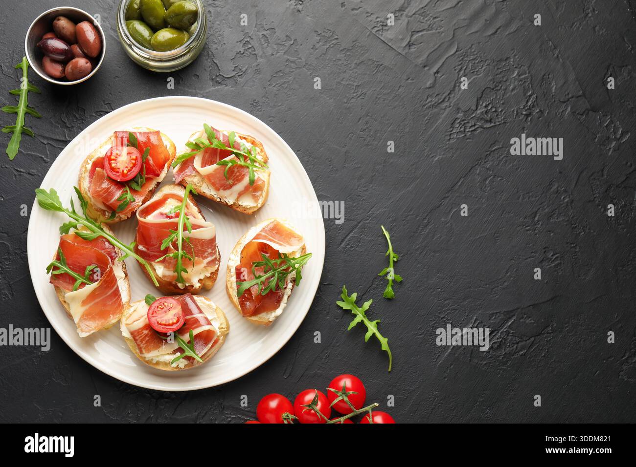 Delicious bruschettas with cream cheese, prosciutto, tomatoes and ...