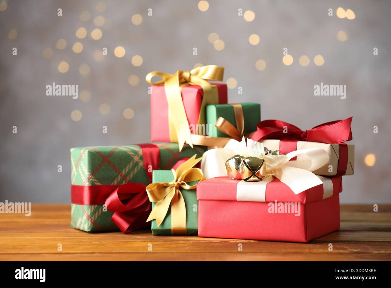 Christmas gift boxes on wooden table against grey background with bokeh ...