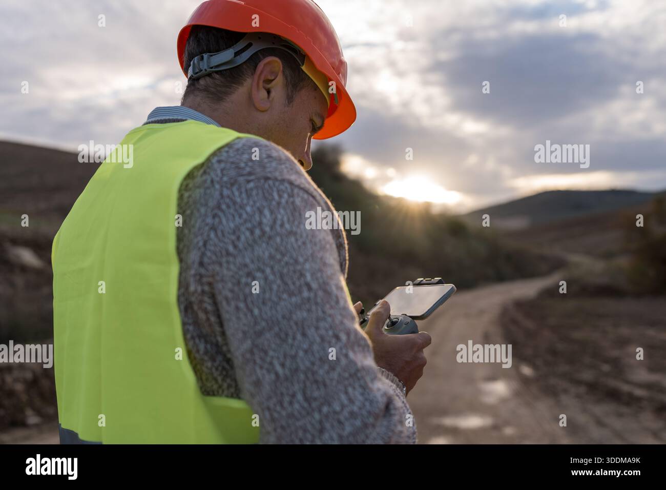 Engineer wearing safety helmet and vest using drone remote control for ...