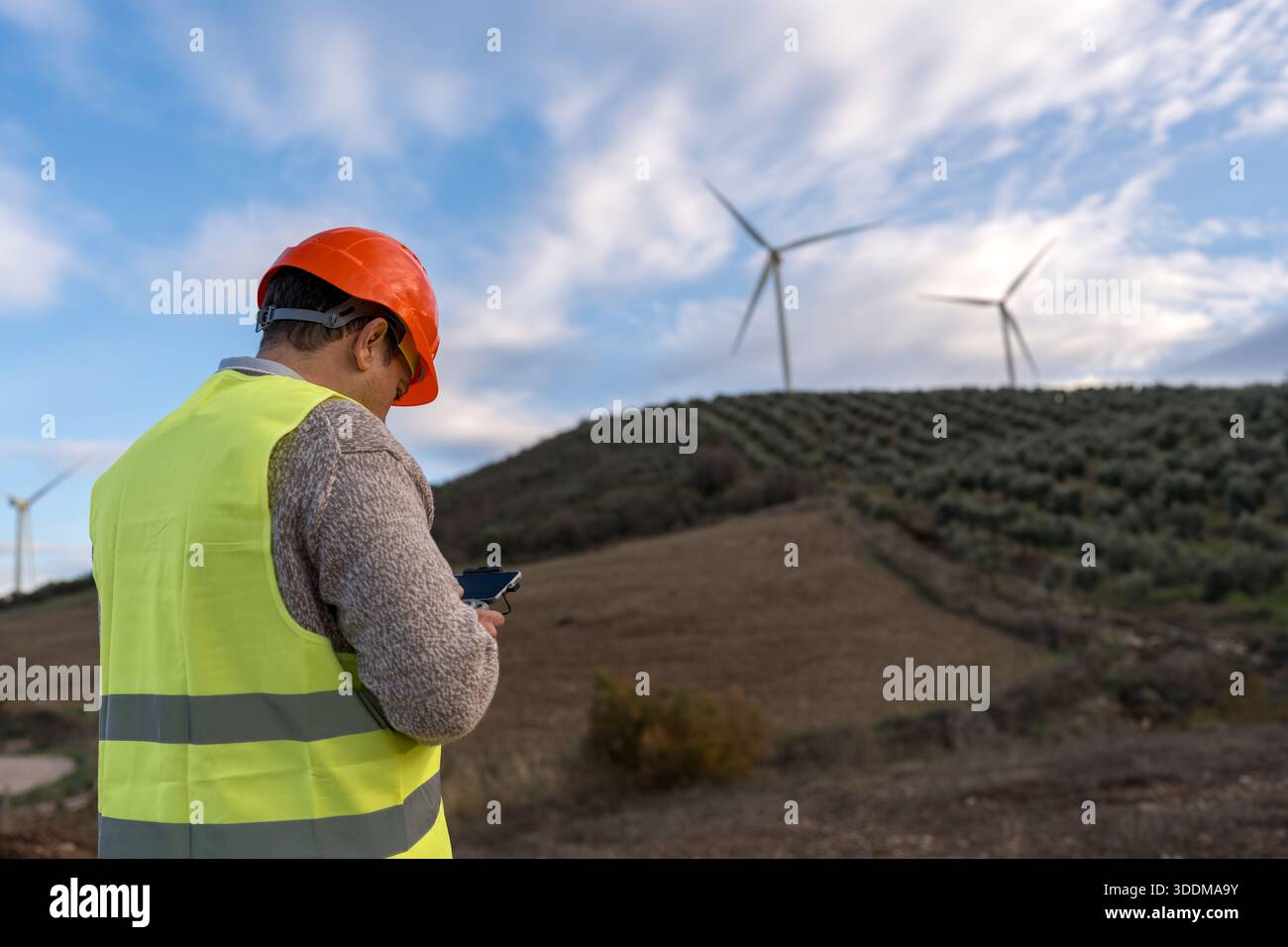 Engineer wearing safety vest and hard hat operating a remote control ...