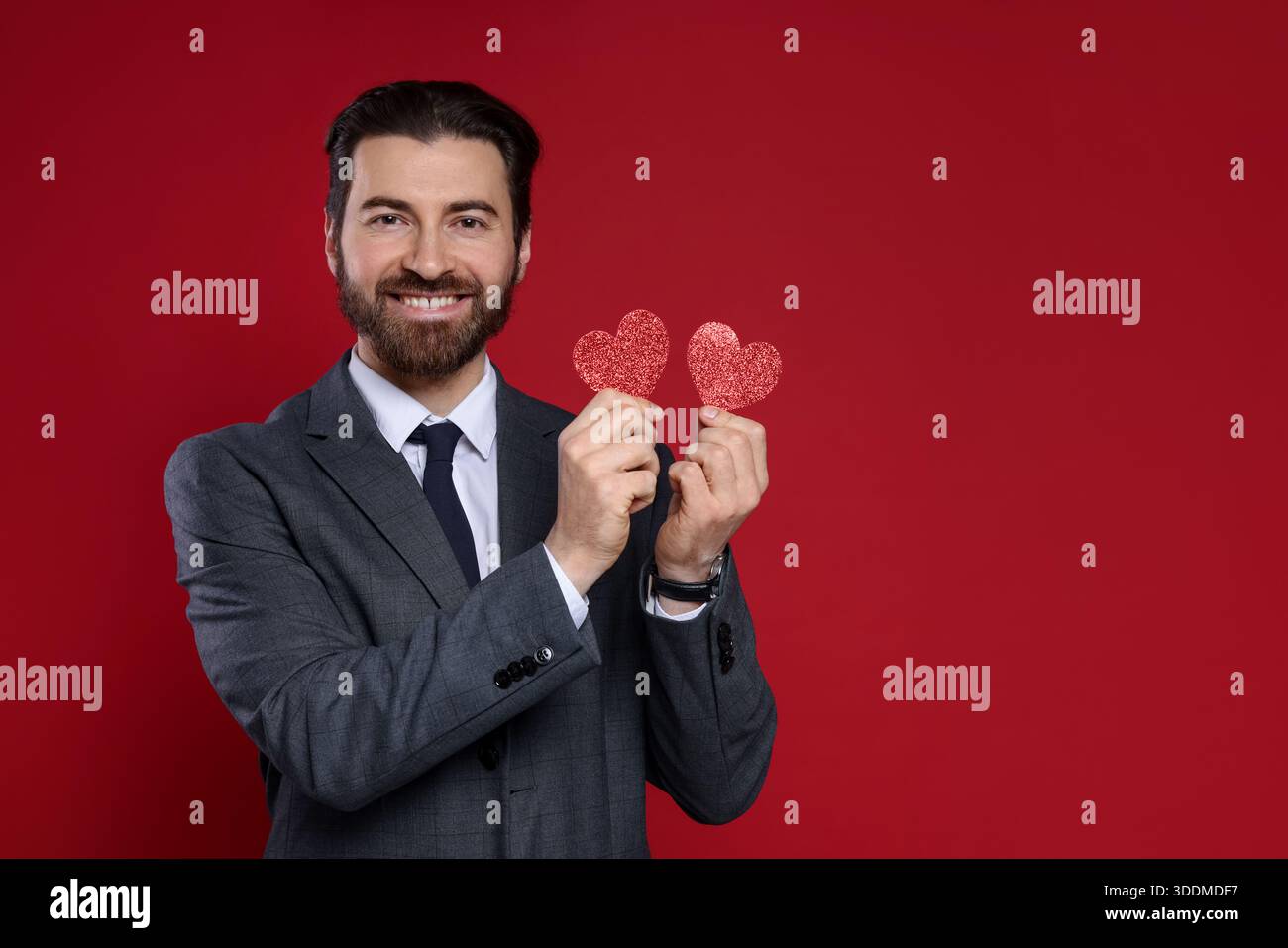 St. Valentine's Day. Man with paper hearts on red background. Space for ...