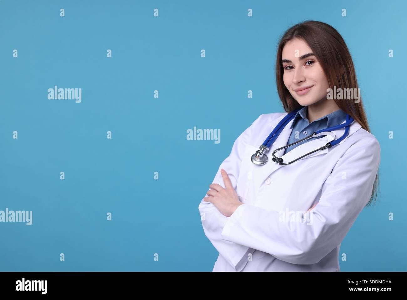 Portrait of medical assistant on light blue background, space for text ...