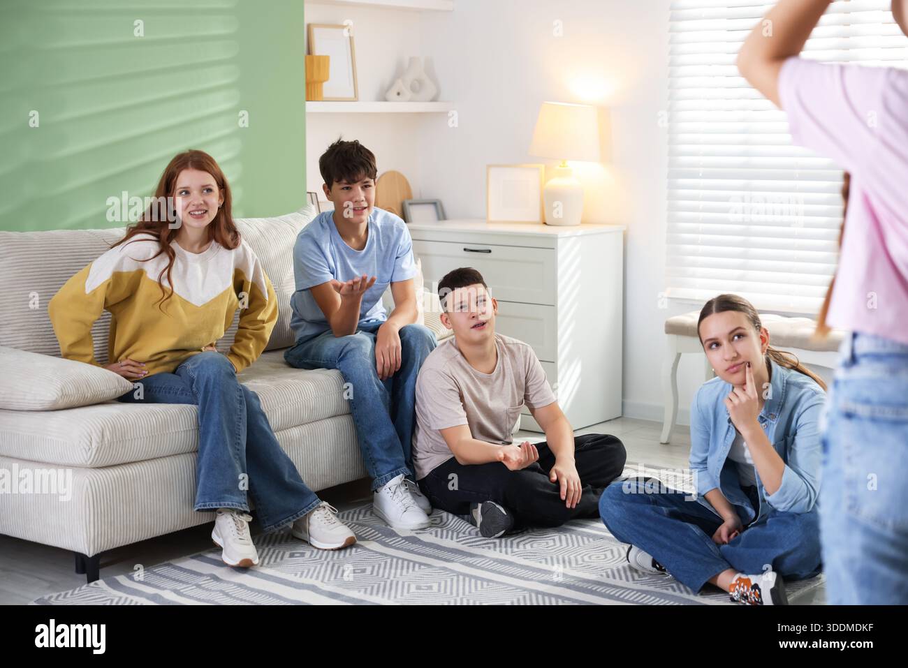 Group of teenagers playing charades game at home Stock Photo - Alamy