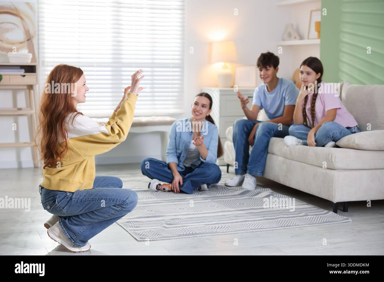 Group of teenagers playing charades game at home Stock Photo - Alamy
