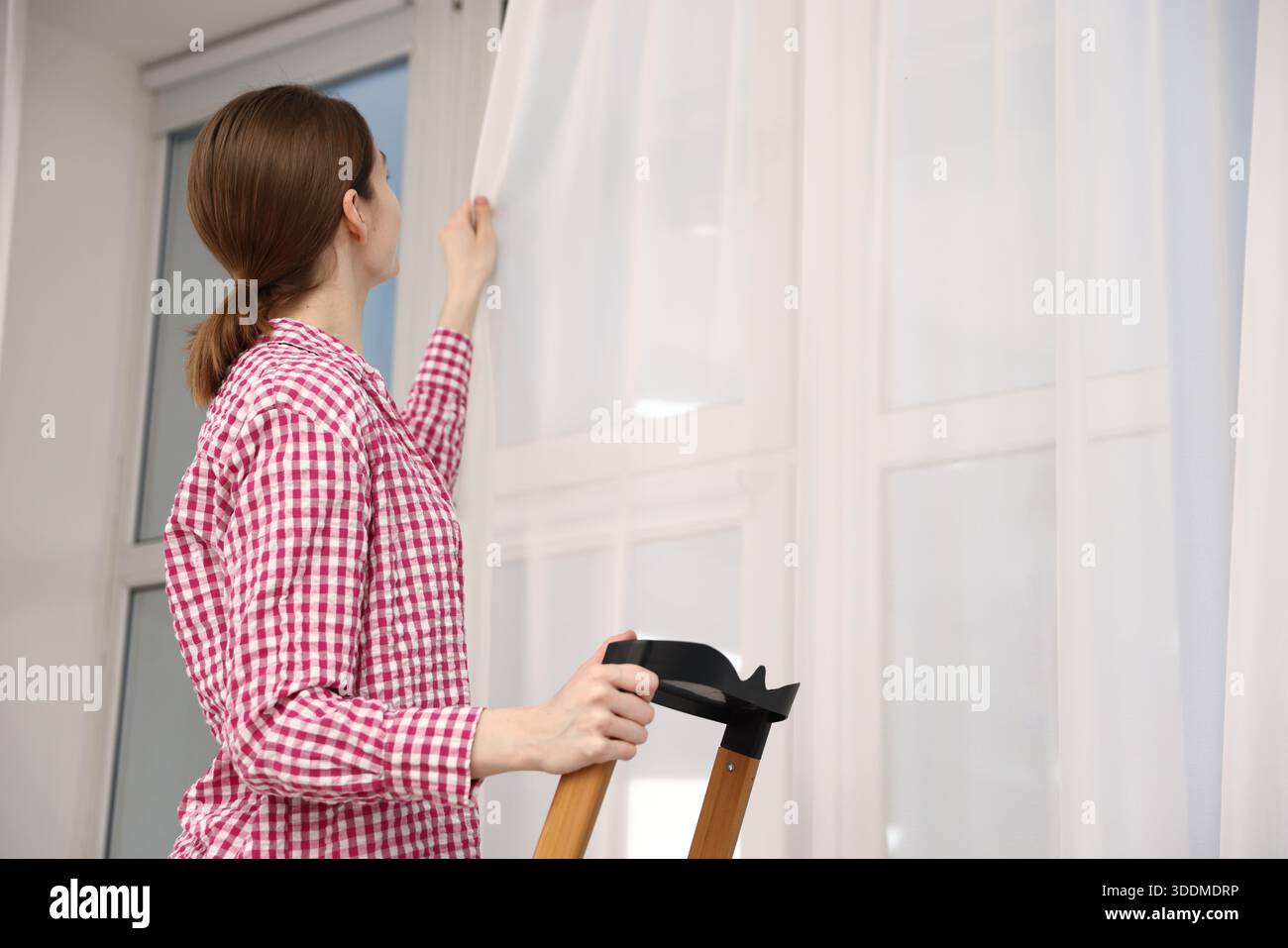 Woman ladder hanging up window hi-res stock photography and images - Alamy