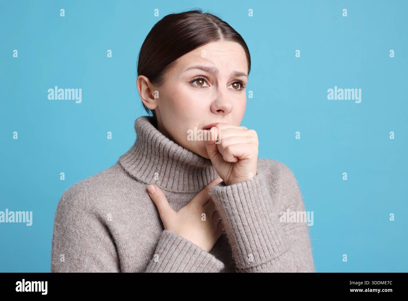 Woman coughing on light blue background. Cold symptom Stock Photo - Alamy
