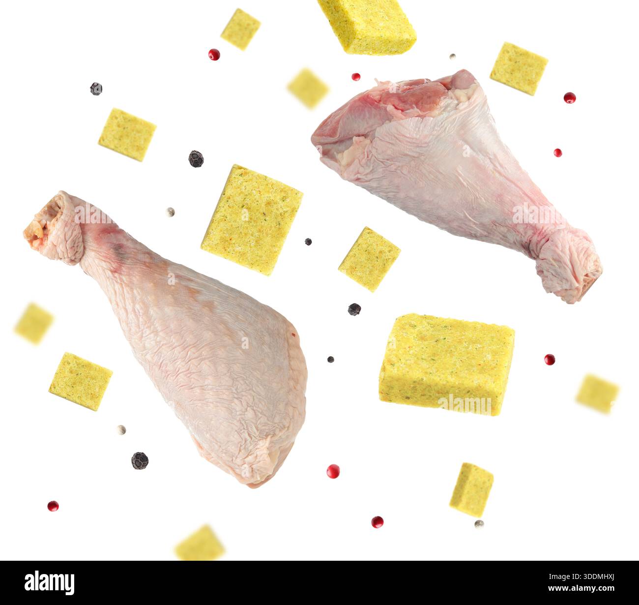 Bouillon cubes, chicken drumsticks and peppercorns flying in air on ...