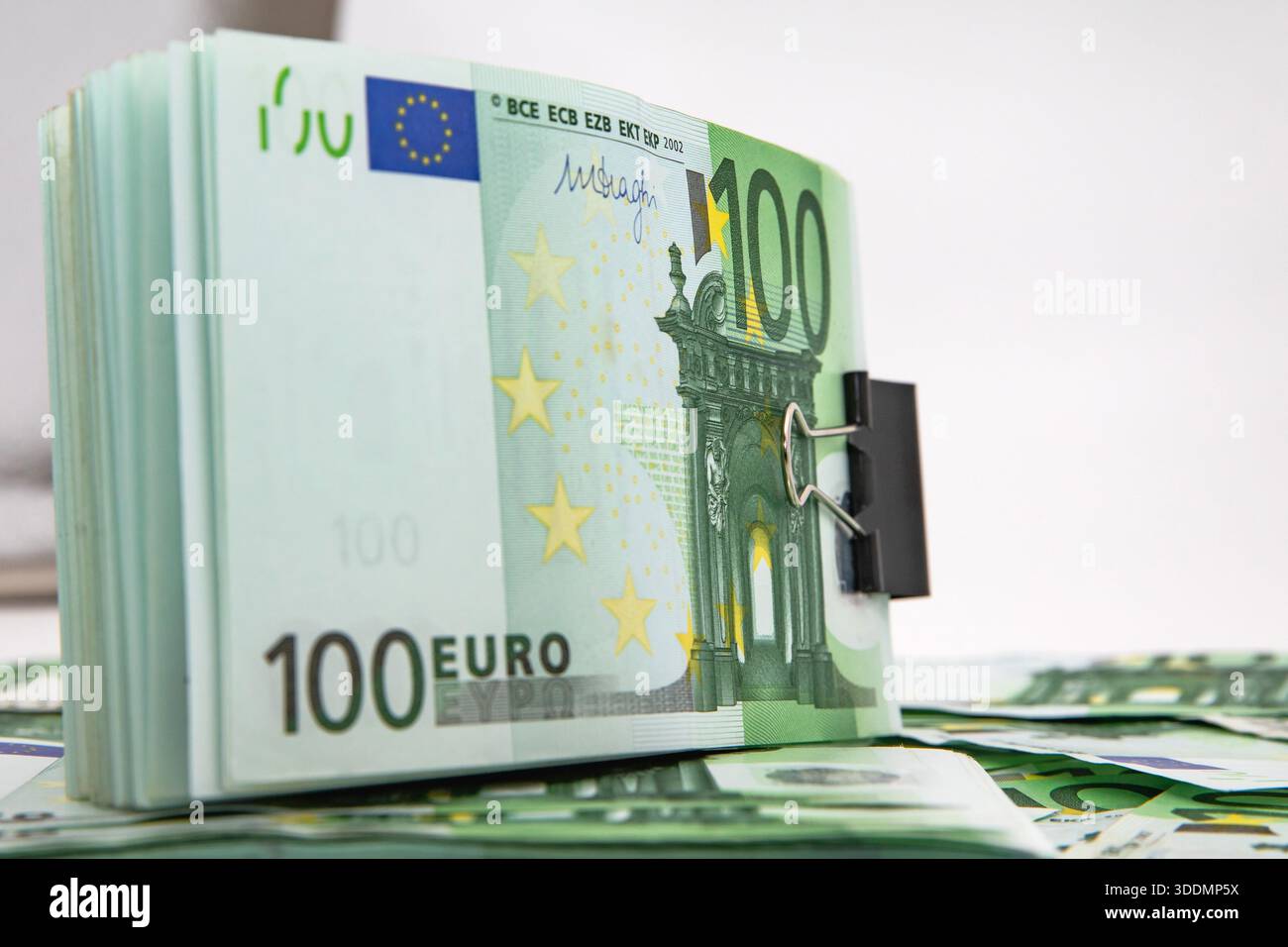 Stack of one hundred euro banknotes clipped together on clean white ...