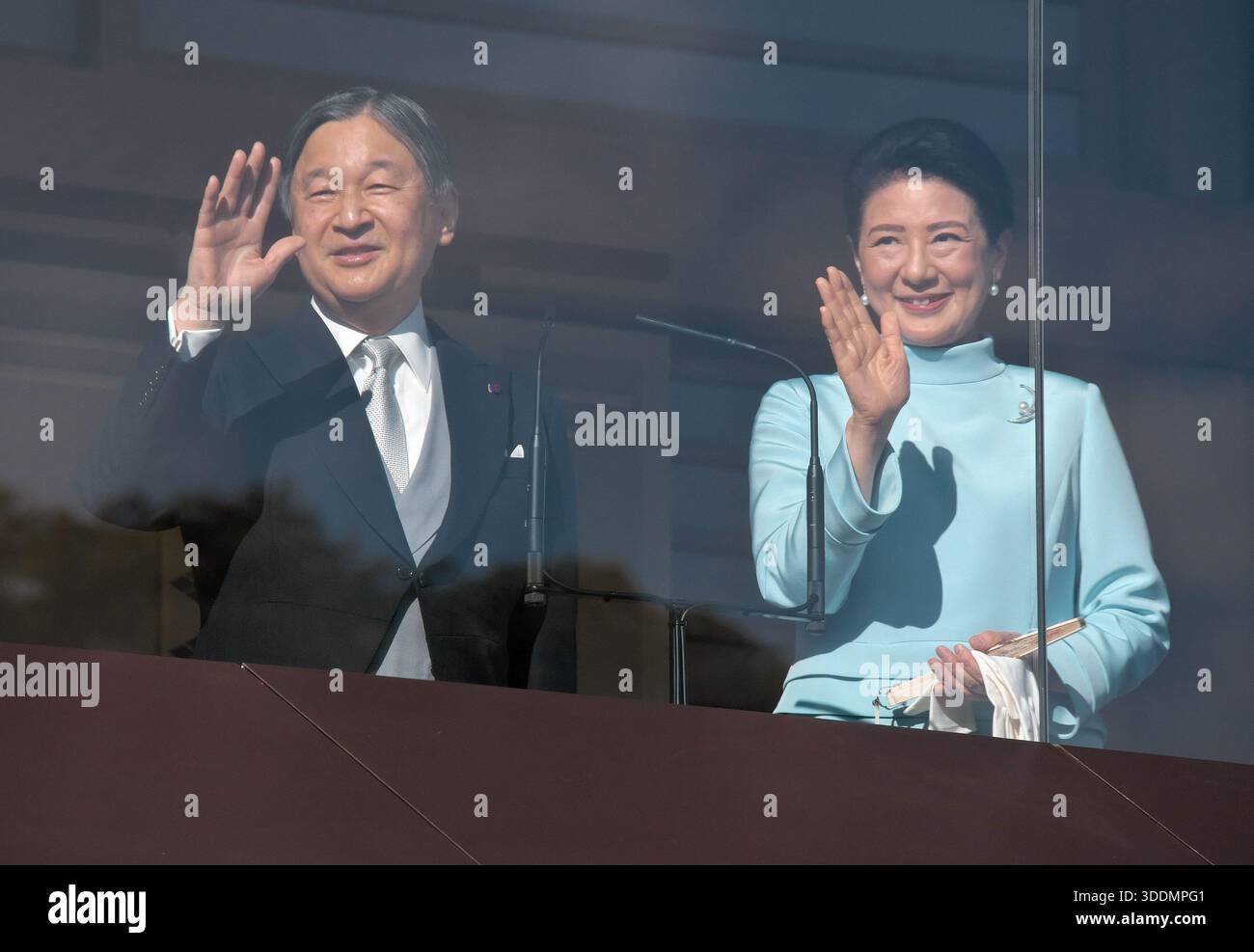 Japan's Emperor Naruhito(L) and Empress Masako wave to well-wishers during the new year greeting ...