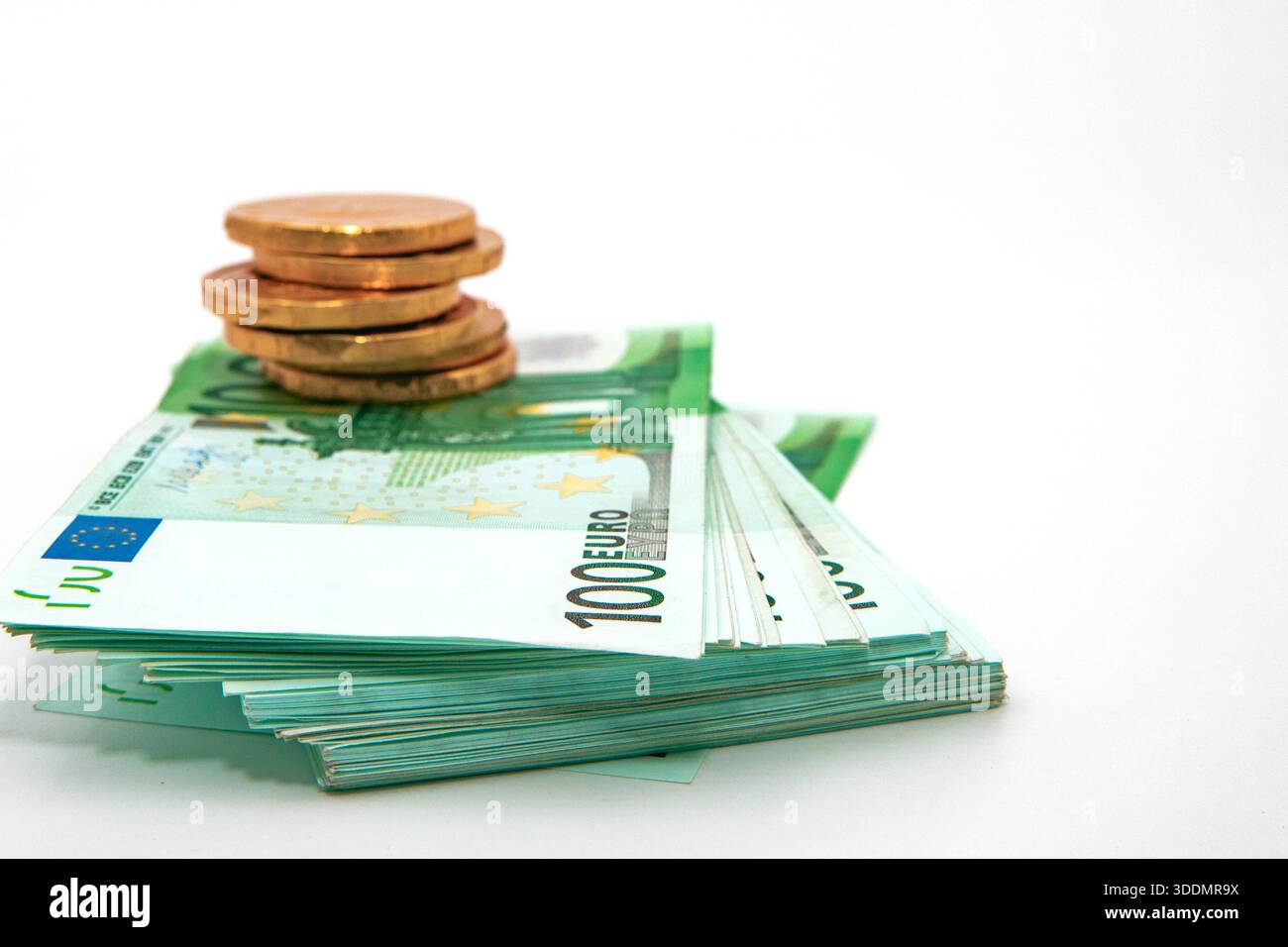Stack of euro banknotes with gold coins on white background copy space ...