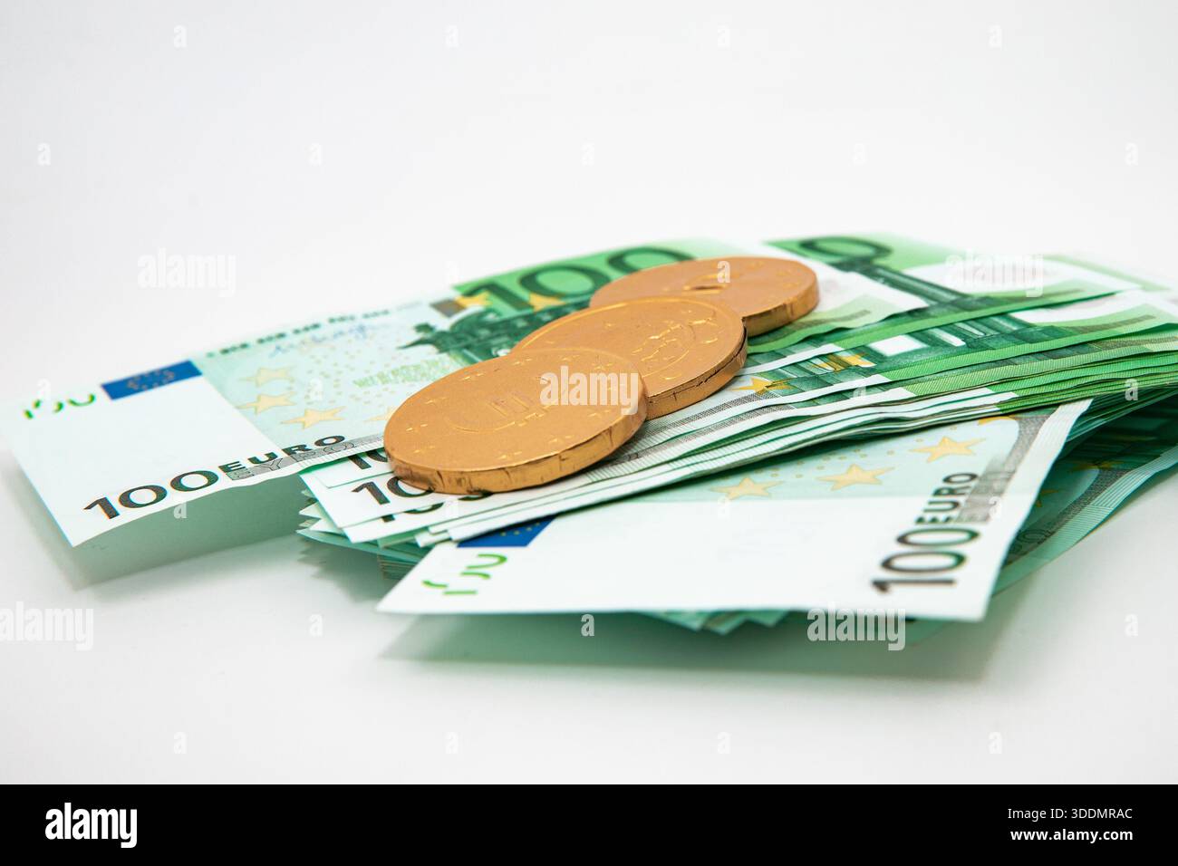 Stack of euro banknotes with gold coins on white background copy space ...