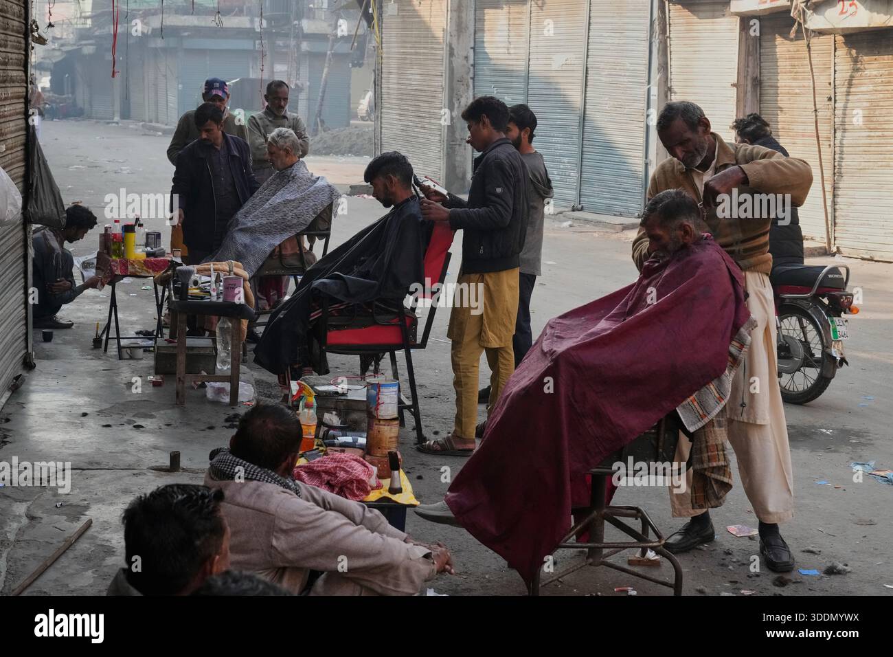 Local residents get their haircut from street barbers in an old ...