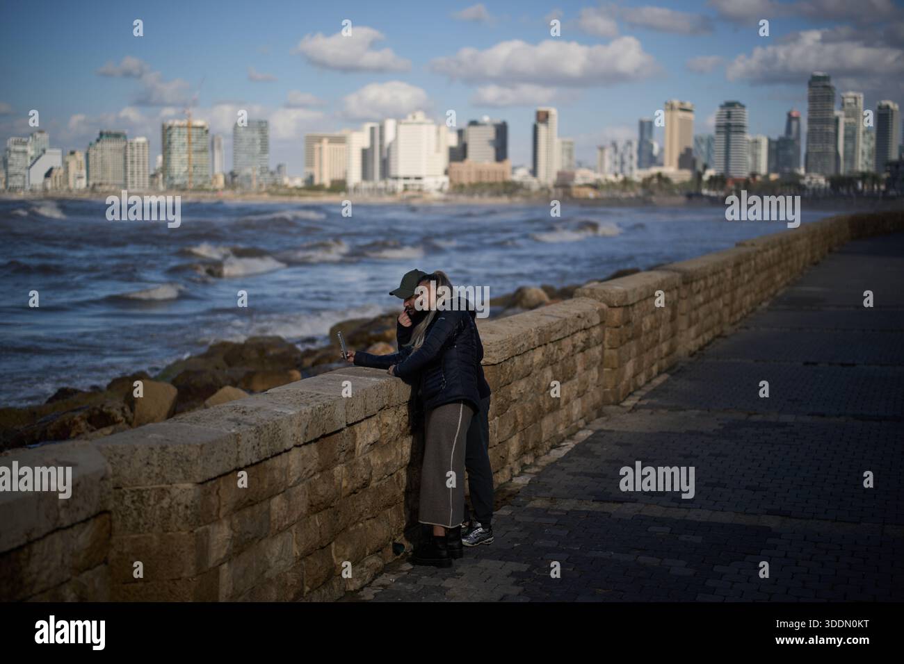 A couple take a selfie at the promenade near the old port of Jaffa, a ...