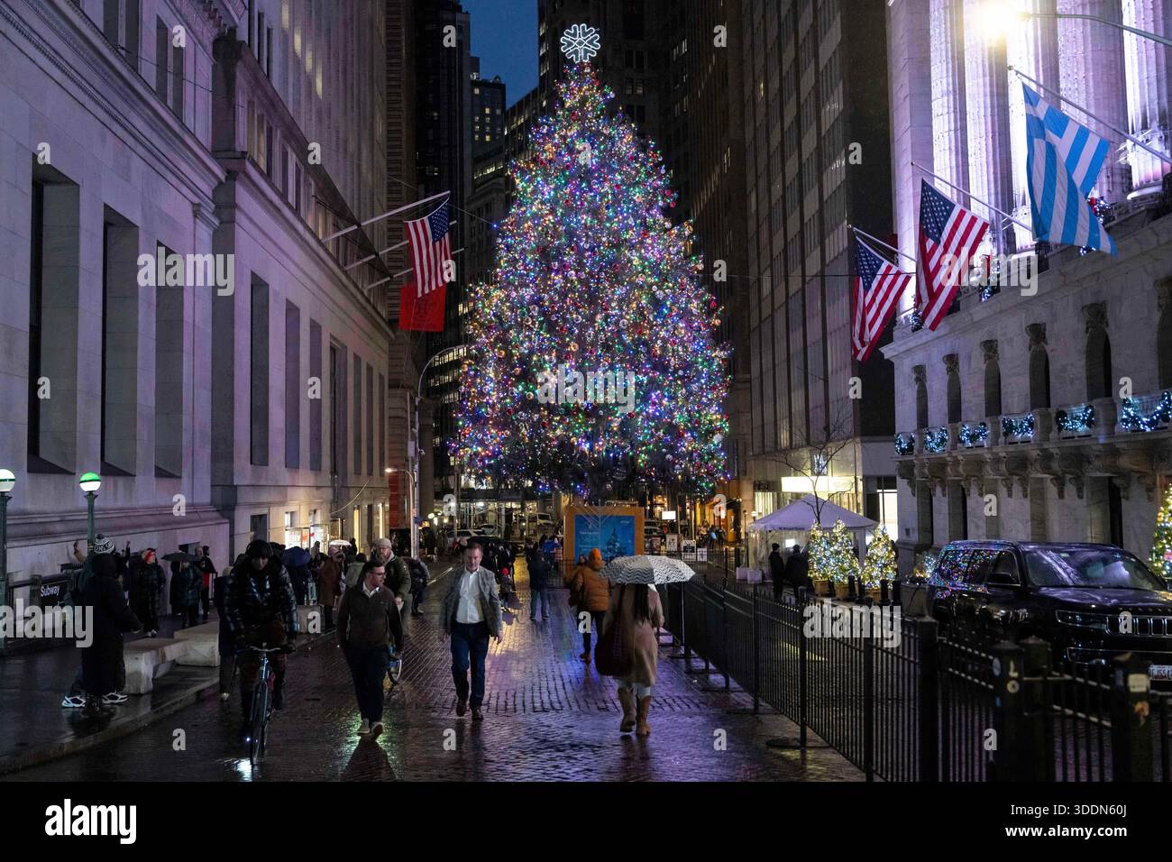 FILE - People walk past a Christmas tree outside the New York Stock ...