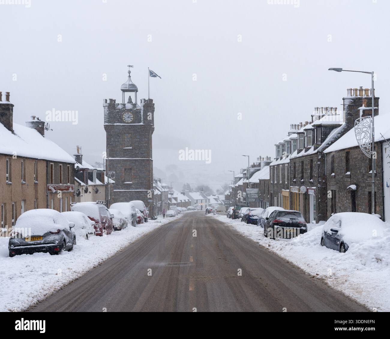 Snow blankets the streets of Dufftown in Moray, Scotland. Cars are ...