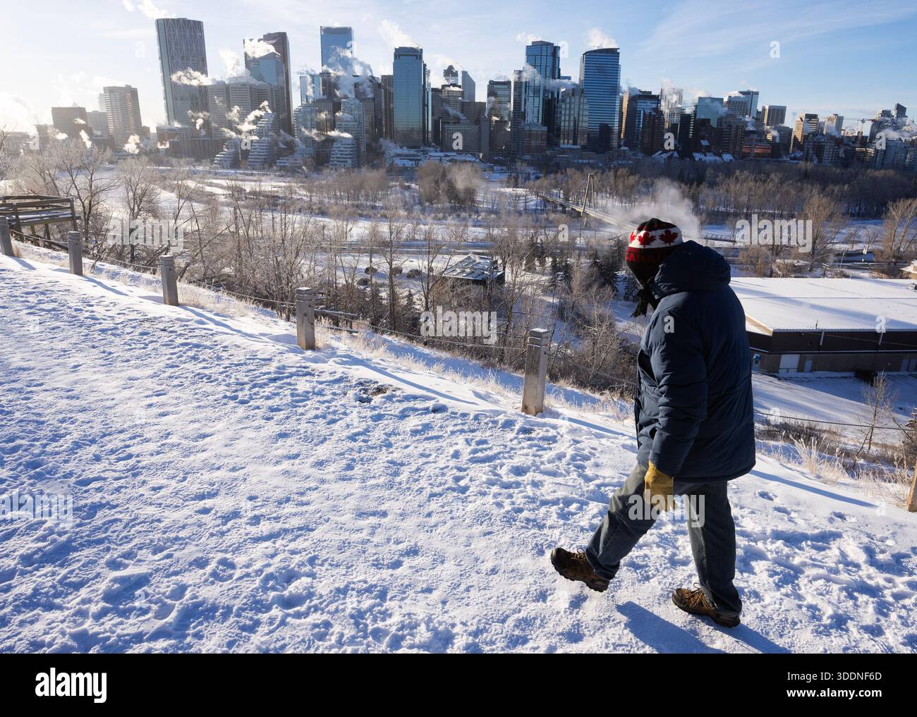 A man walks by the city skyline in Calgary, Alta., Monday, Jan. 15 ...